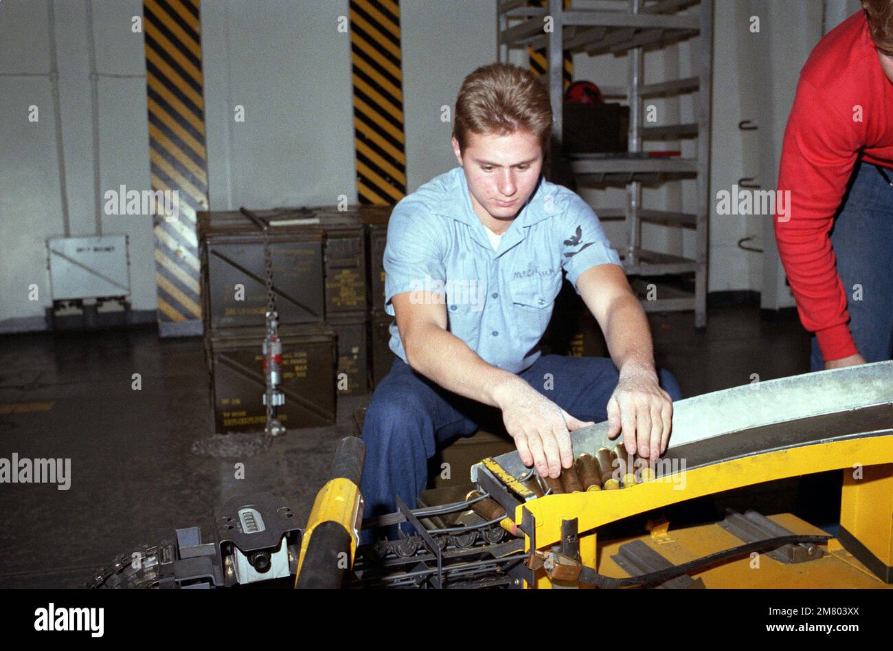 An aviation ordnancemen places 20 mm machine gun ammunition in load ...