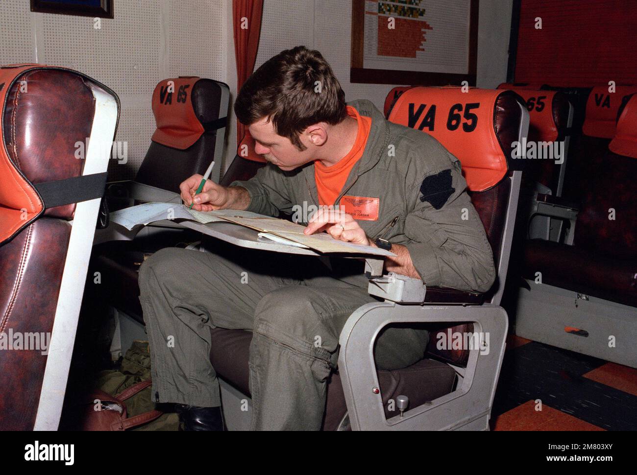 A member of Attack Squadron 65 (VA-65) takes notes during a preflight ...