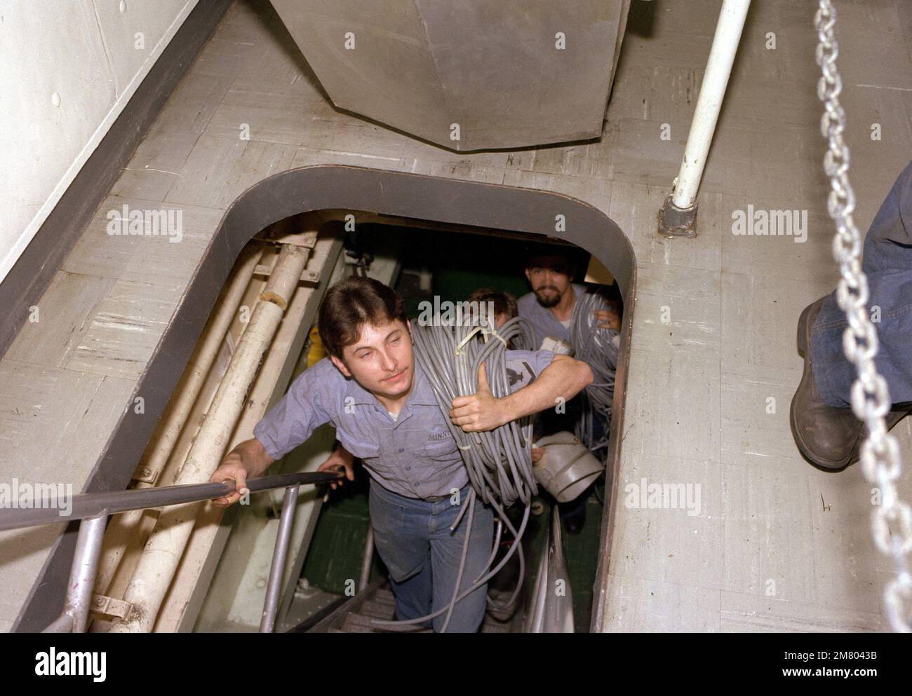 A ship's electrician comes up a ladder aboard the nuclear-powered ...