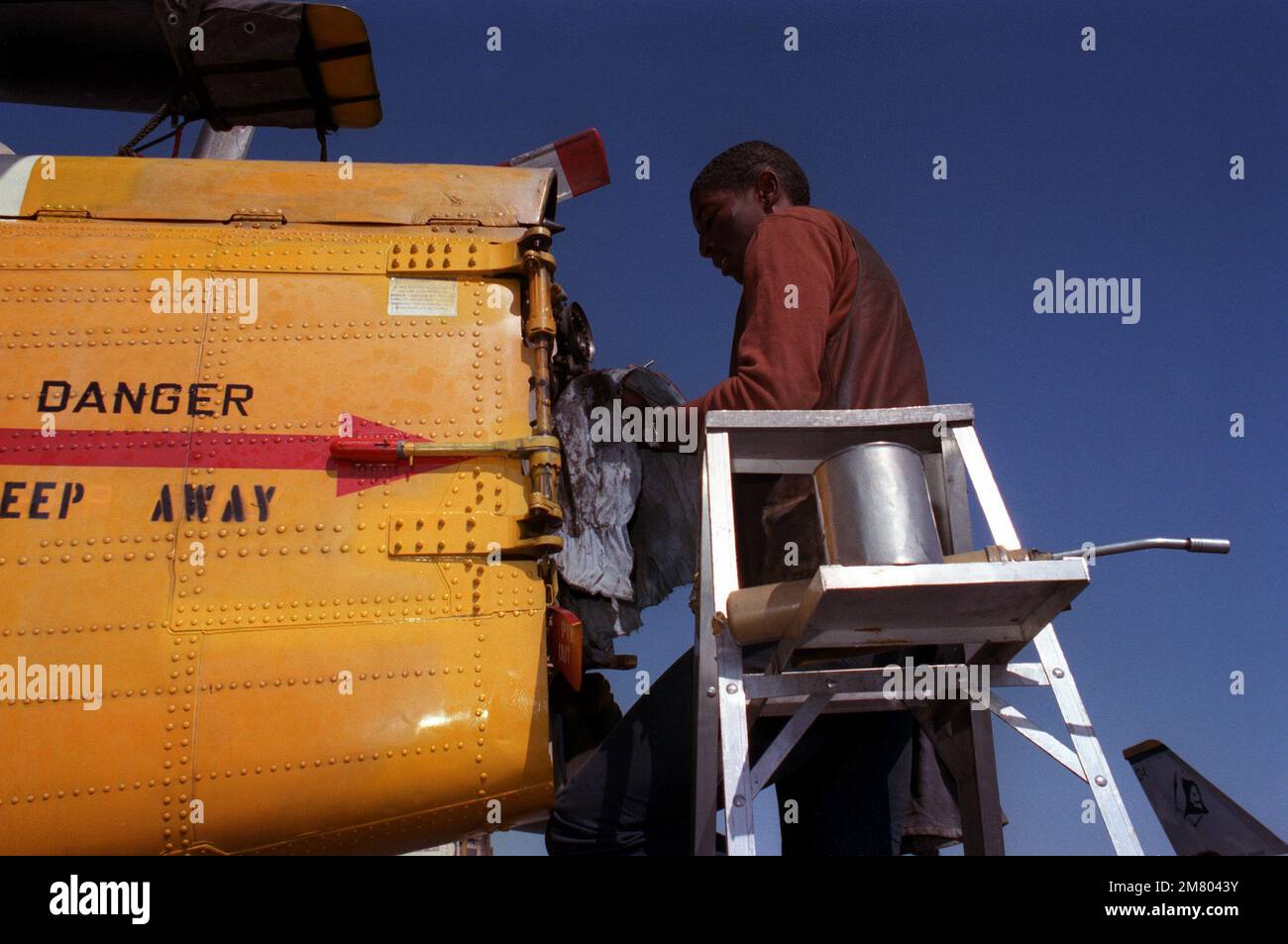 A crewman works on the tail section of a Helicopter Anti-submarine ...