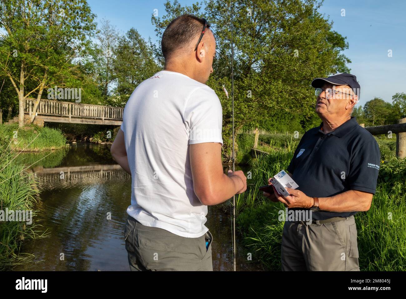 WATER BAILIFF CHECKING THE PERMIT OF A FISHERMAN ON THE ITON RIVER ...