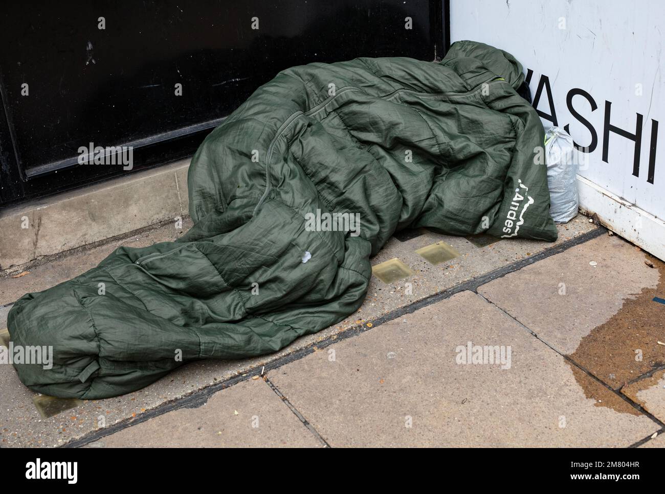 Homeless man in sleeping bag in London street Stock Photo - Alamy