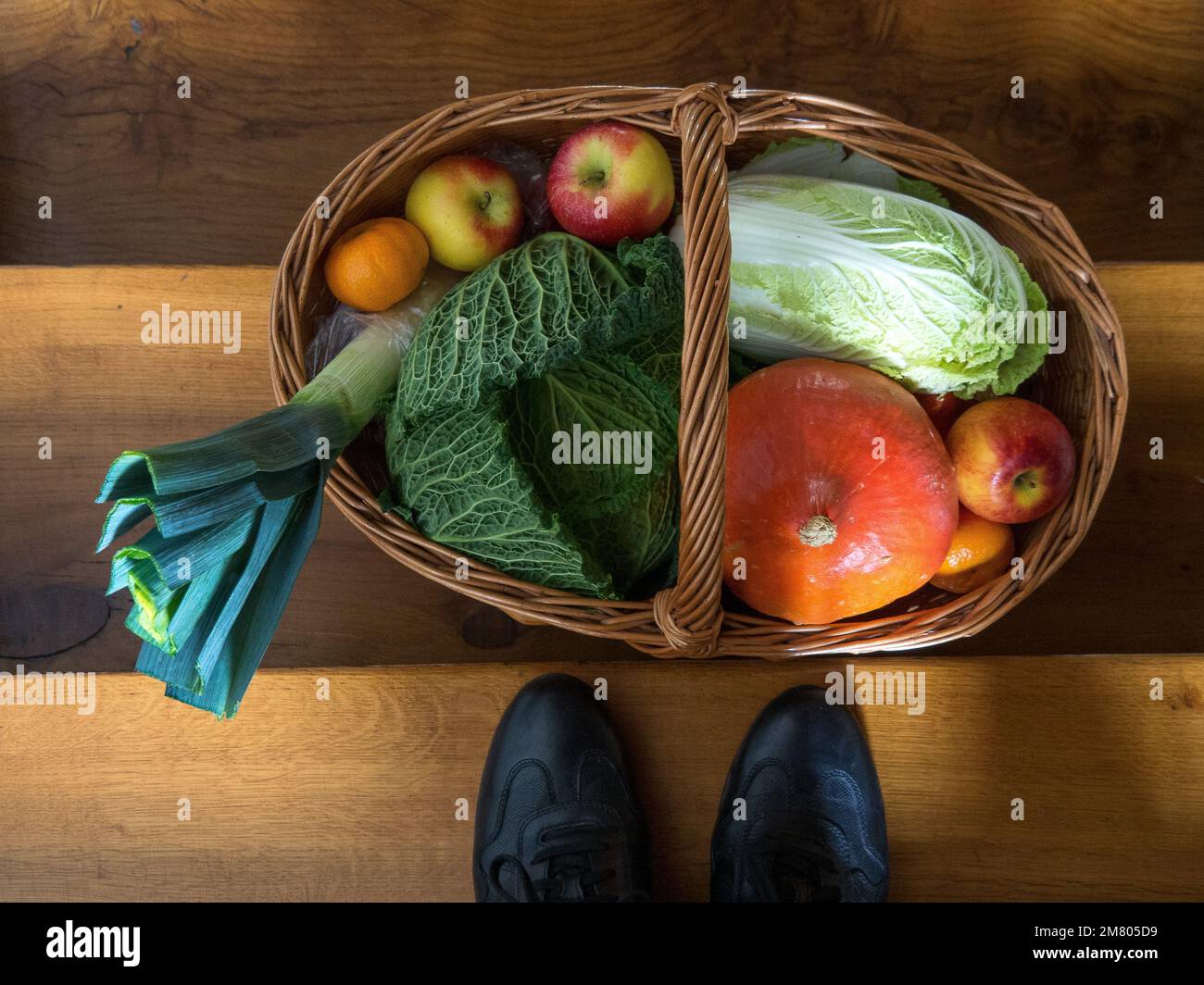 The man's standing in front of full shopping basket with different kind ...