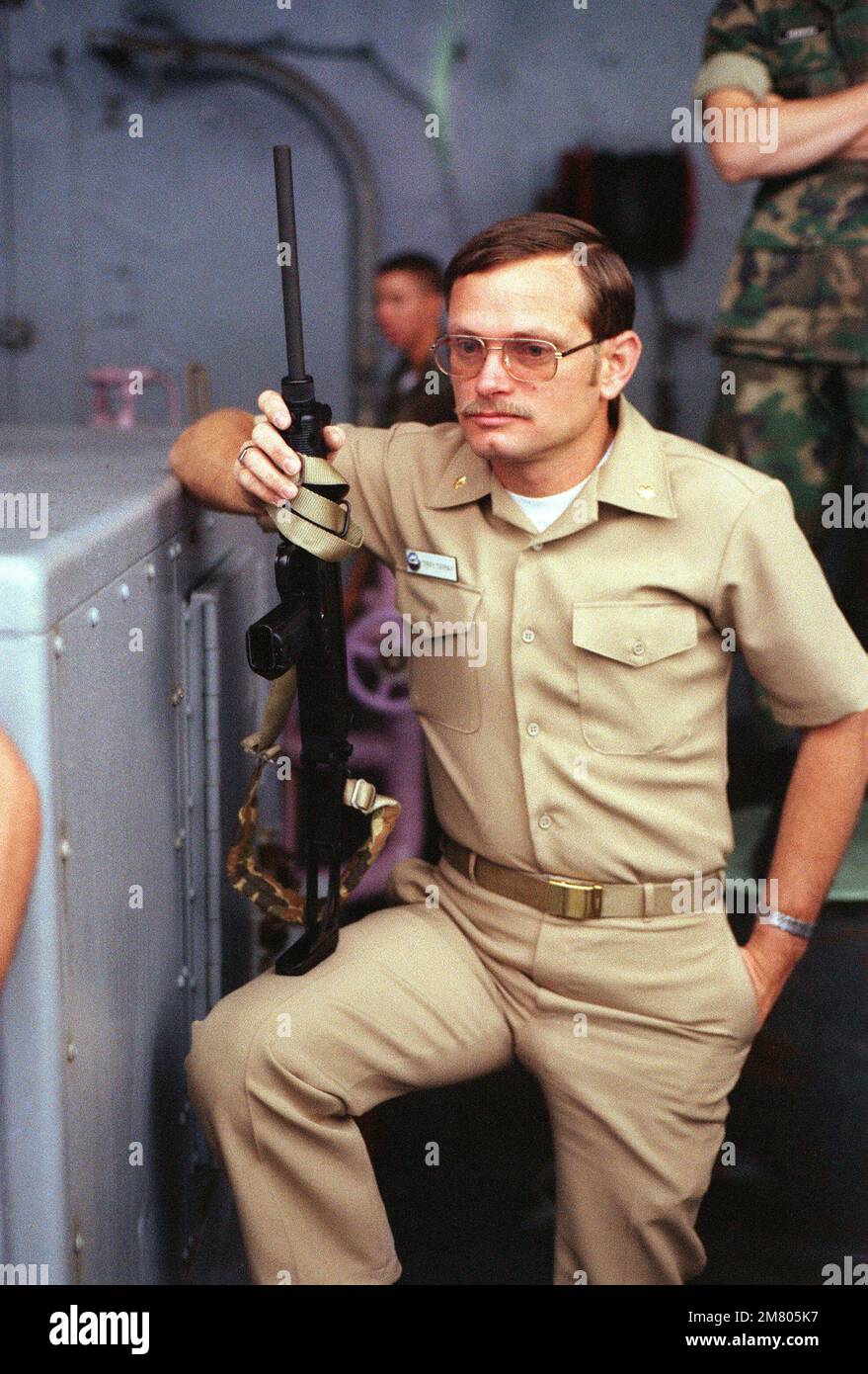 A Navy officer holds an Uzi 9 mm submarine gun during a familiarization ...