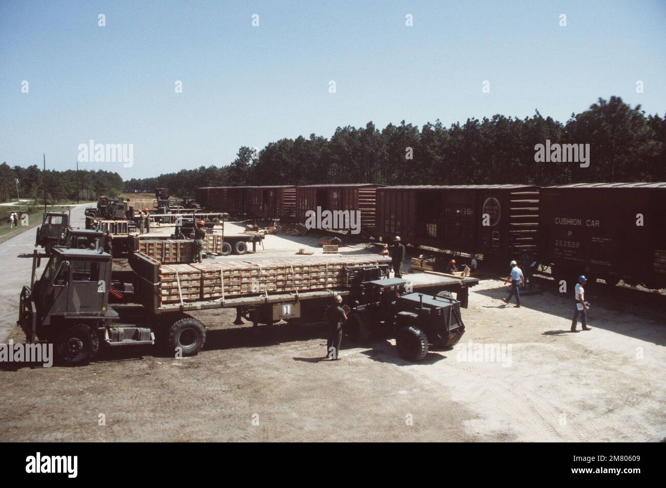 Forklifts are used to unload pallets from railroad cars and place them ...