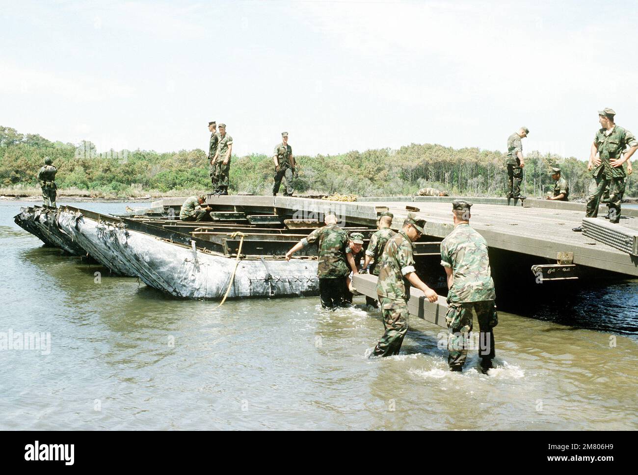 Members of the 2nd Combat Engineers Platoon construct a pontoon bridge ...