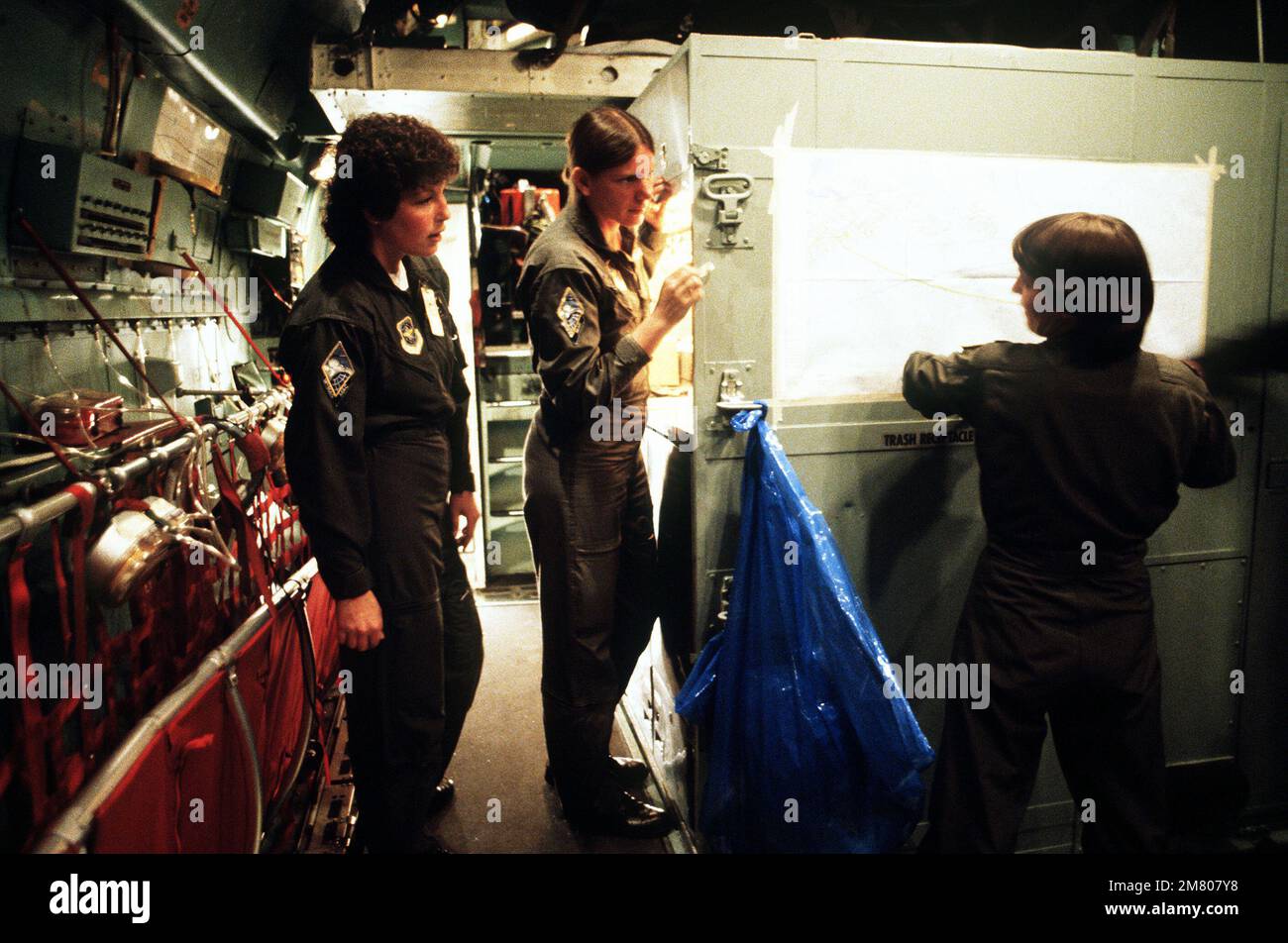 First LT. Terri Ollinger, co-pilot, assembles a map in the passenger ...
