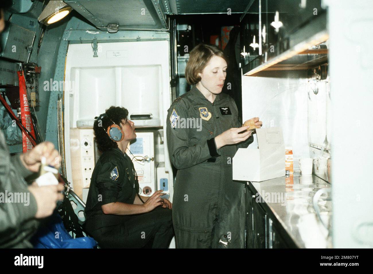 CPT Barbara Akins, first pilot, takes time for a meal while in flight ...