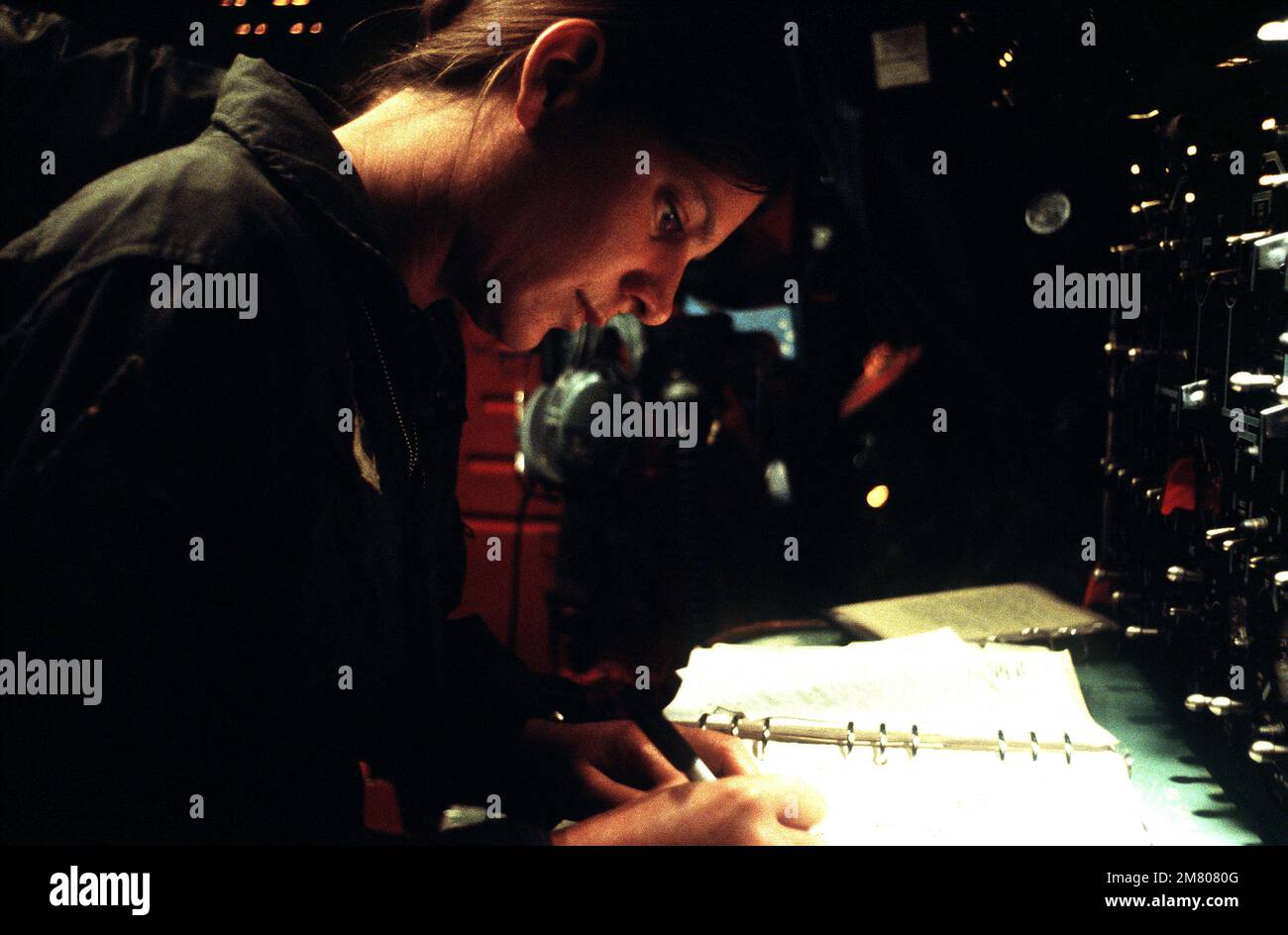 TECH. SGT. Donna Wertz, flight engineer, makes notes while in flight ...