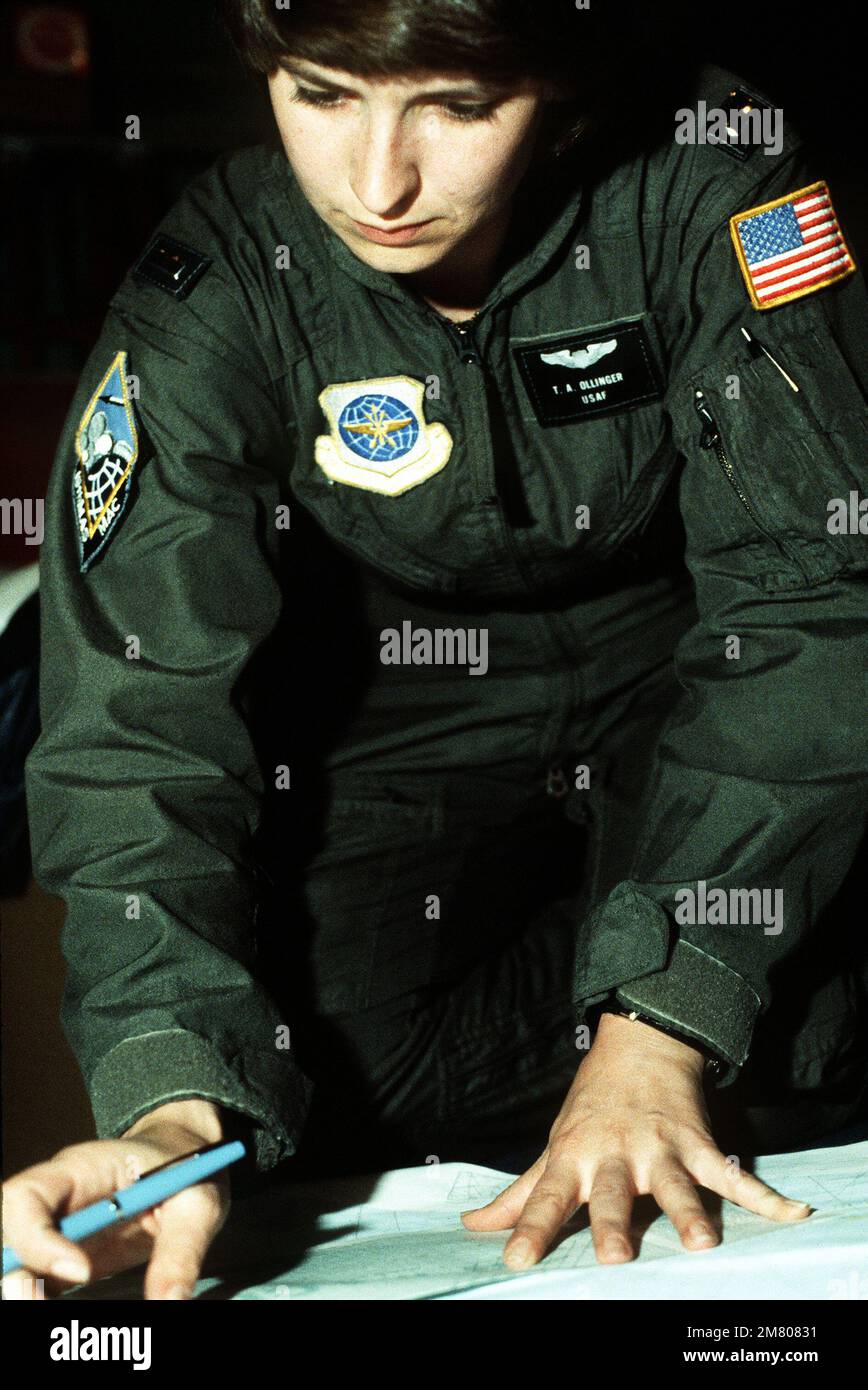 First LT. Terri Ollinger, co-pilot of a C-141 MEDEVAC aircraft, plots a ...