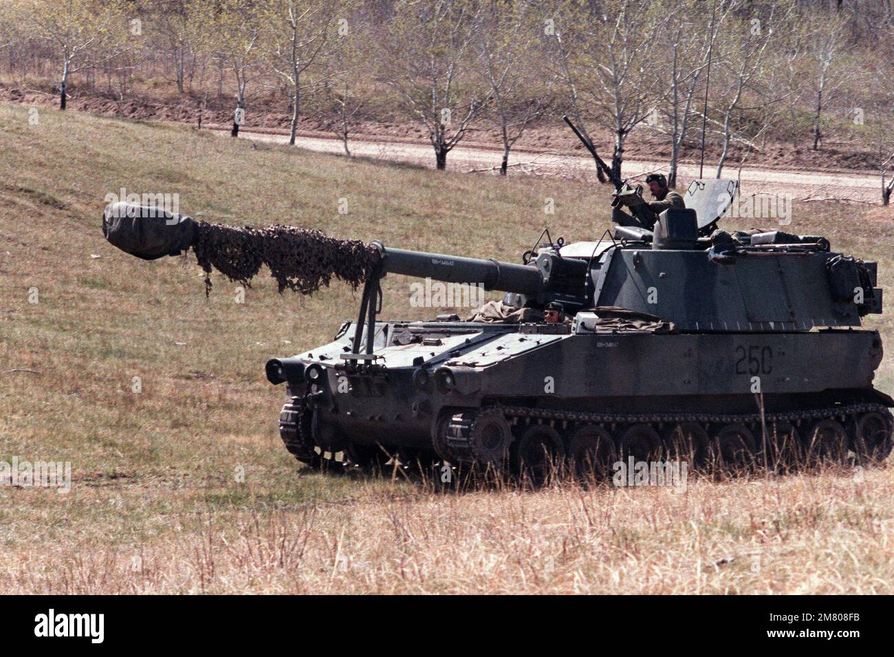 A crew member checks the anti-aircraft machine gun on the turret of a ...