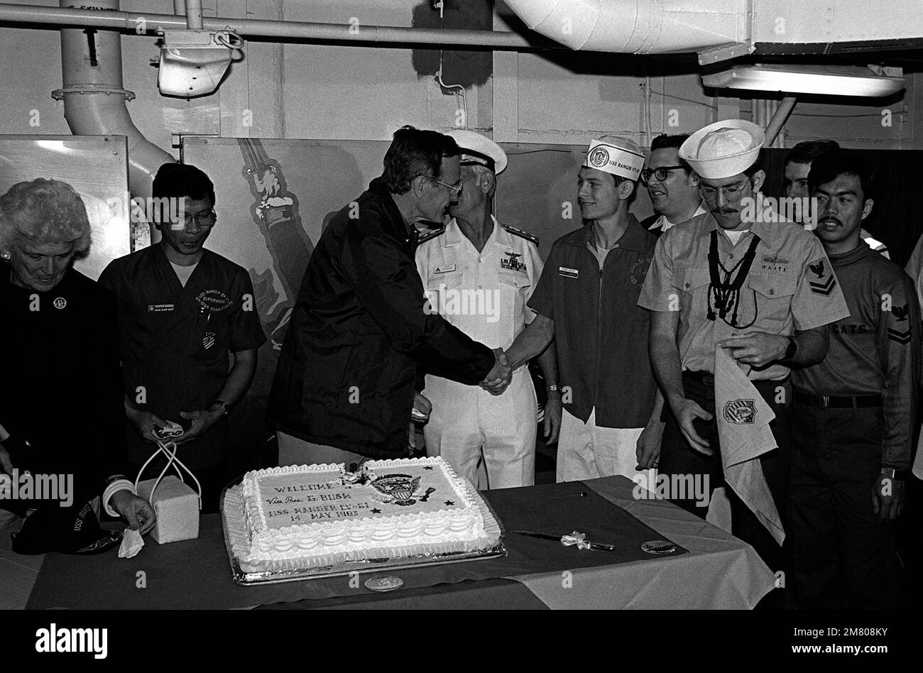 Vice President George Bush congratulates the cook who baked the cake ...