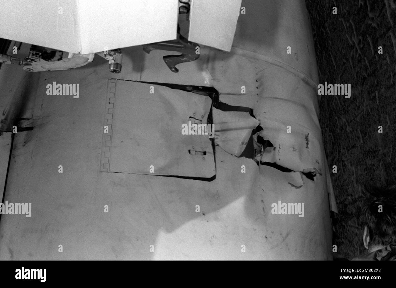 A exterior view of damage to the port engine access door of an A-6E ...