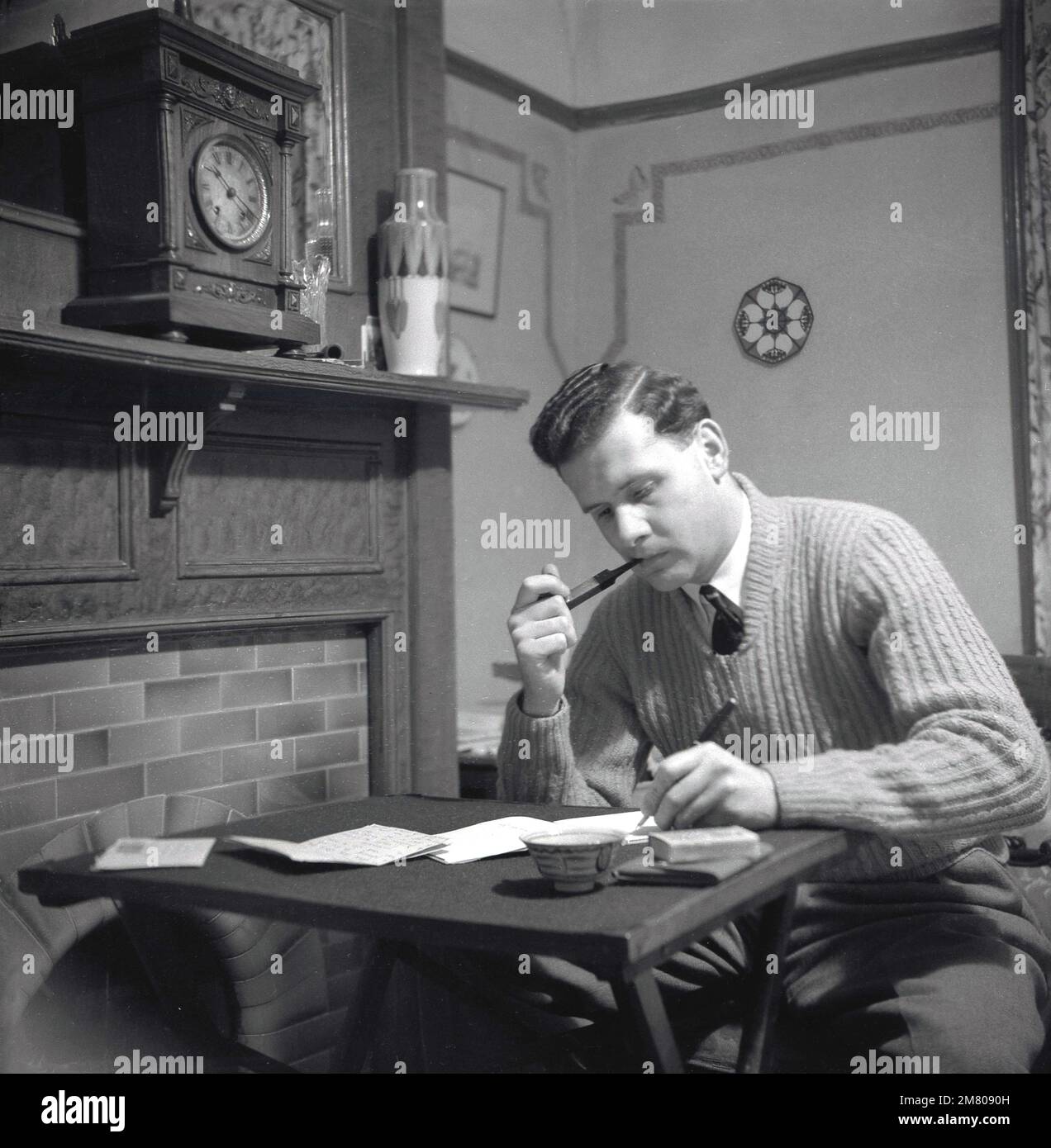 1950s, historical, a man wearing a shirt & tie and sweater sitting at ...