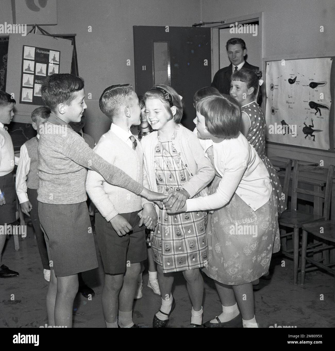 1960s historical, four children, primary school, holding each other's ...