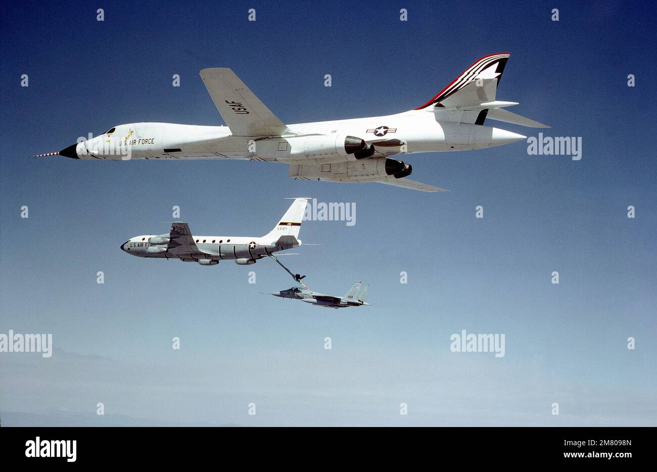 An air-to-air left rear view of a B-1B bomber aircraft. In the ...