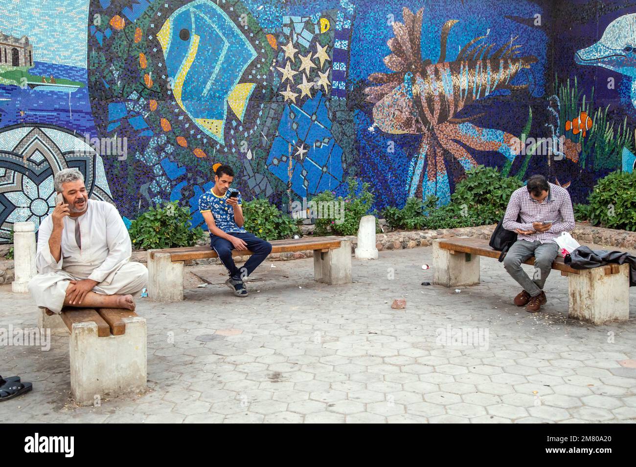 MEN WITH THEIR CELL PHONES IN FRONT OF THE ENTRANCE TO THE MOSAIC ...