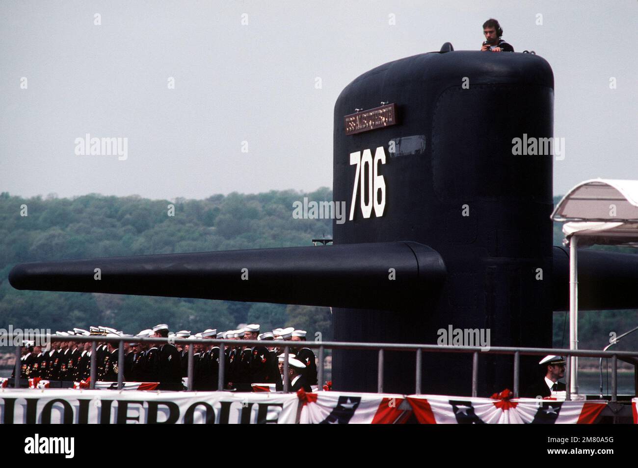 Crew members of the nuclear-powered attack submarine USS ALBUQUERQUE (SSN-706) stand under the ...