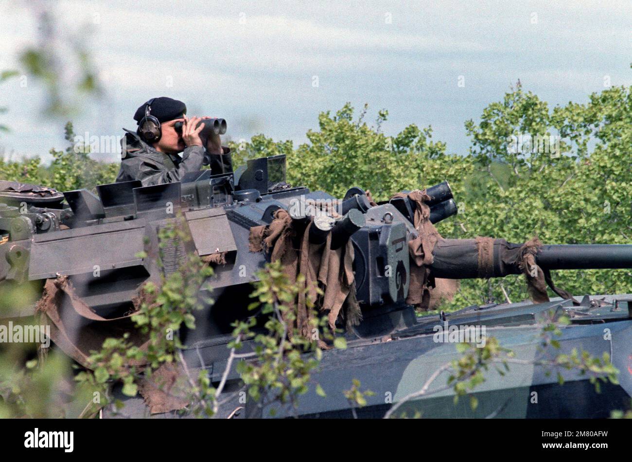 A Canadian soldier observes troop movements from the turret of a ...
