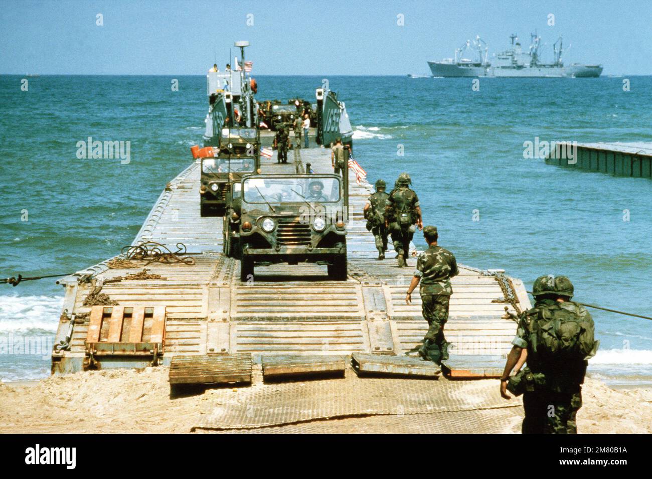A view of Marines coming ashore in jeeps from a utility landing craft ...