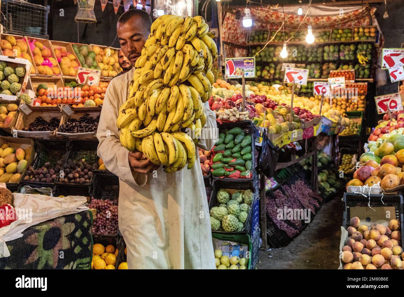 VENDOR WITH HIS BUNCH OF BANANAS, FRUIT AND VEGETABLE STAND, EL DAHAR ...