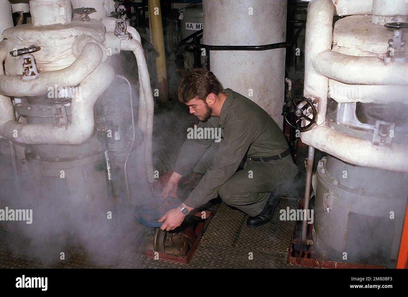 A boilerman technician opens the discharge valve to the main feed ...