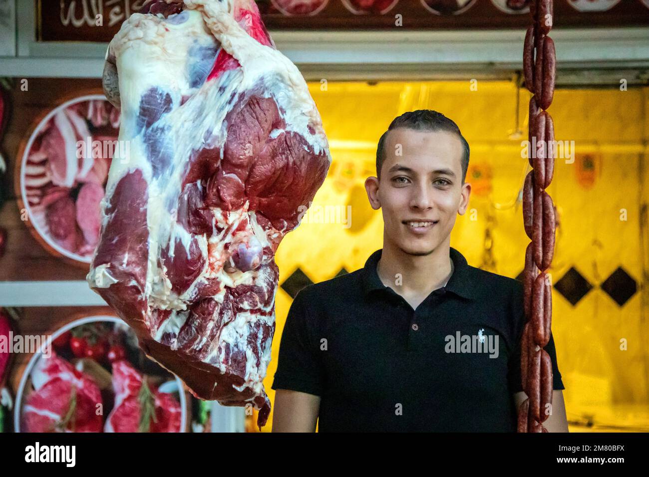 YOUNG BUTCHER IN FRONT OF HIS MEAT, EL DAHAR MARKET, POPULAR QUARTER IN ...