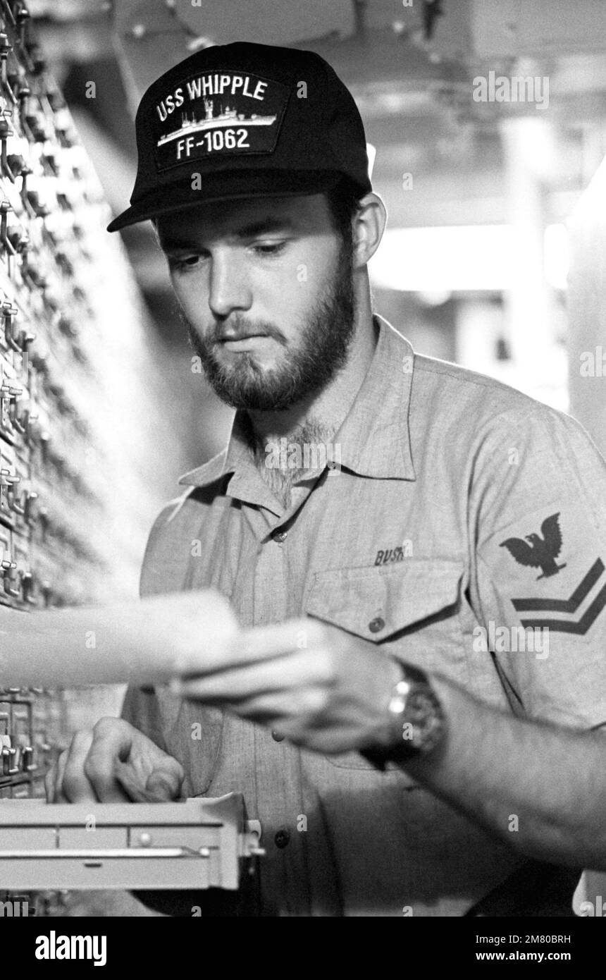 Storekeeper 2nd Class Dean Bush uses a computer card to search for a ...