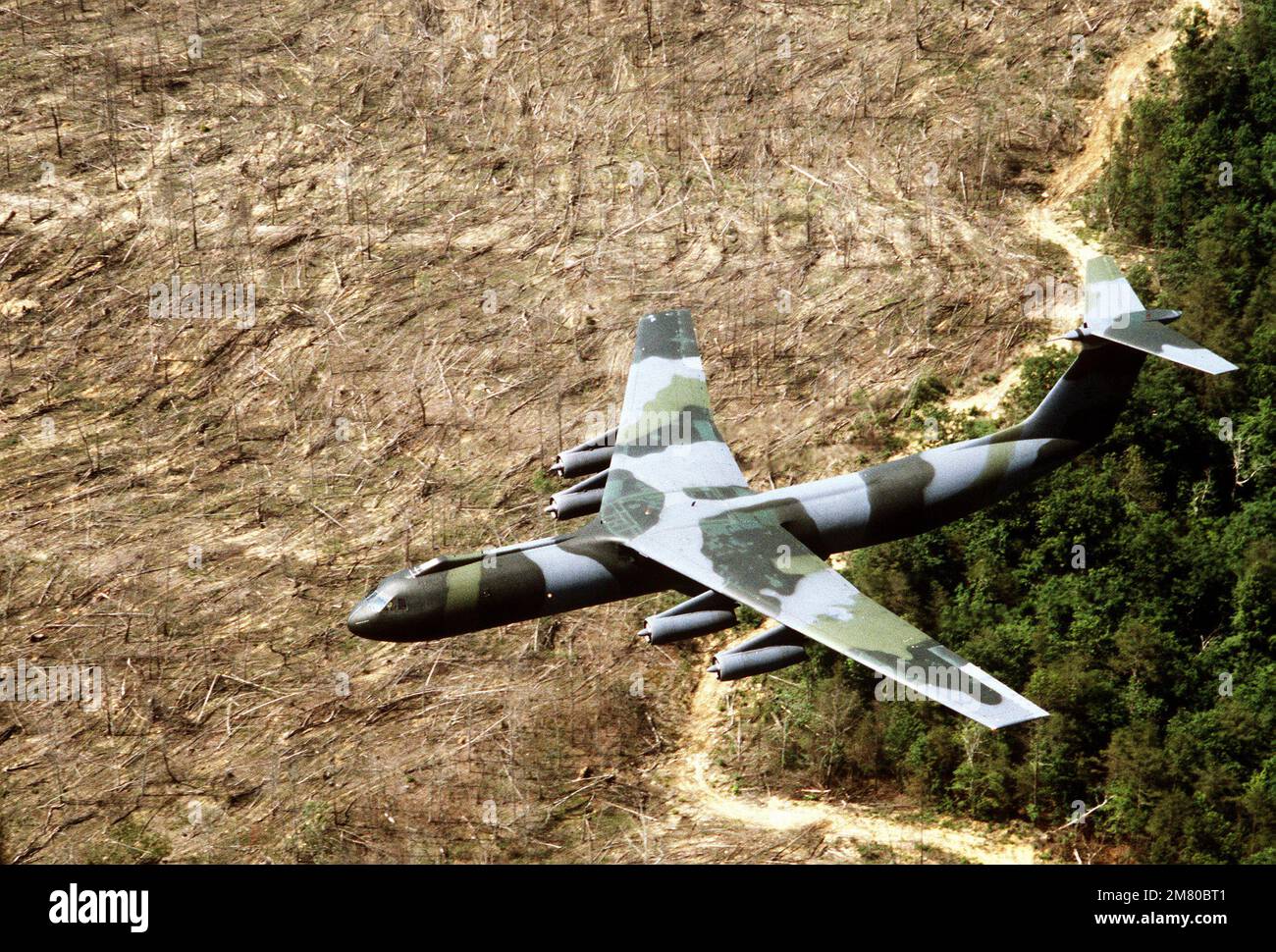 An air-to-air left front view of a C-141 Starlifter aircraft in a ...