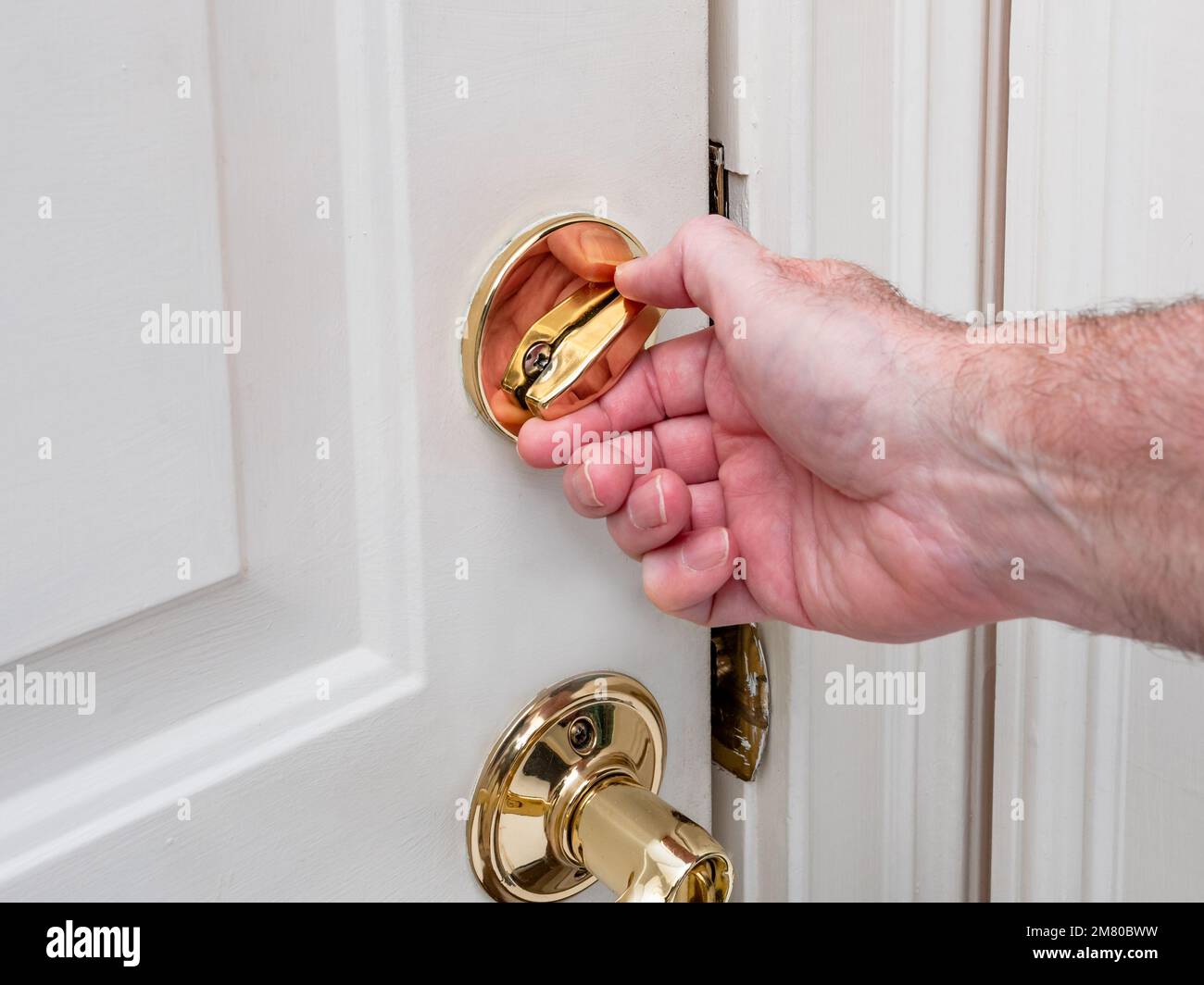 Man locking deadbolt door lock on white entry door. Home security ...