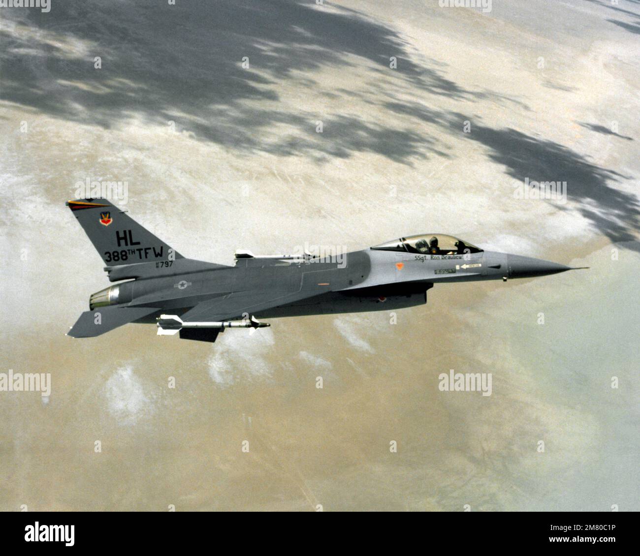 An air-to-air right side view of an F-16 Fighting Falcon aircraft over ...