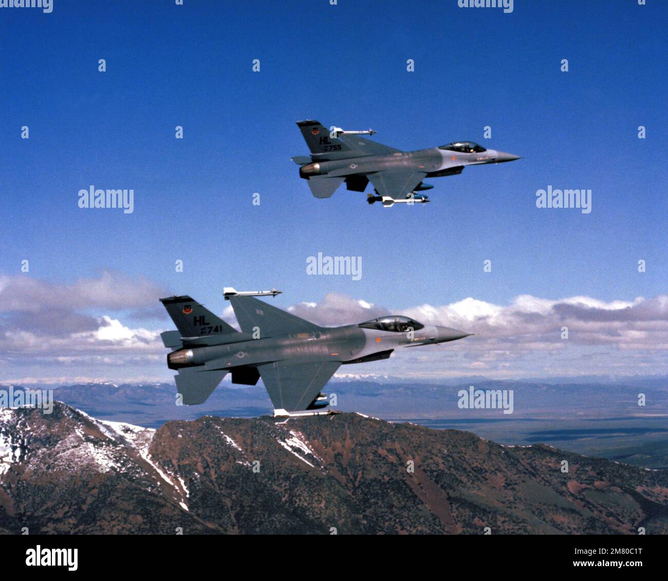 An air-to-air right side view of two F-16 Fighting Falcon aircraft ...