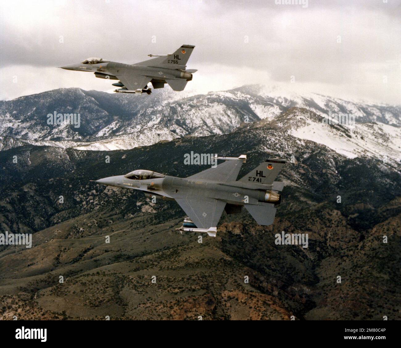 An air-to-air left side view of two F-16 Fighting Falcon aircraft ...