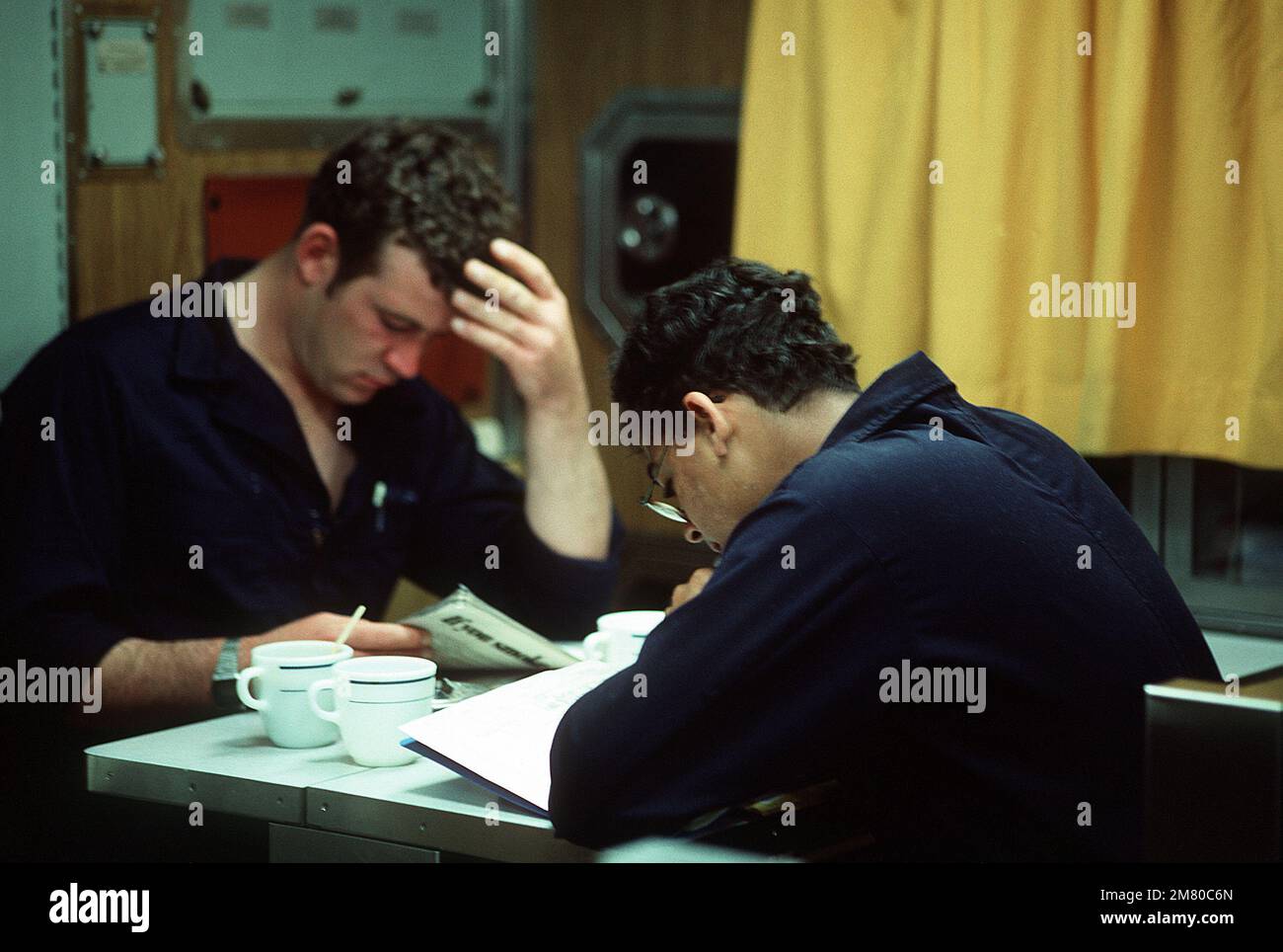 Crewmen studying in the mess deck are aboard the Los Angeles class ...