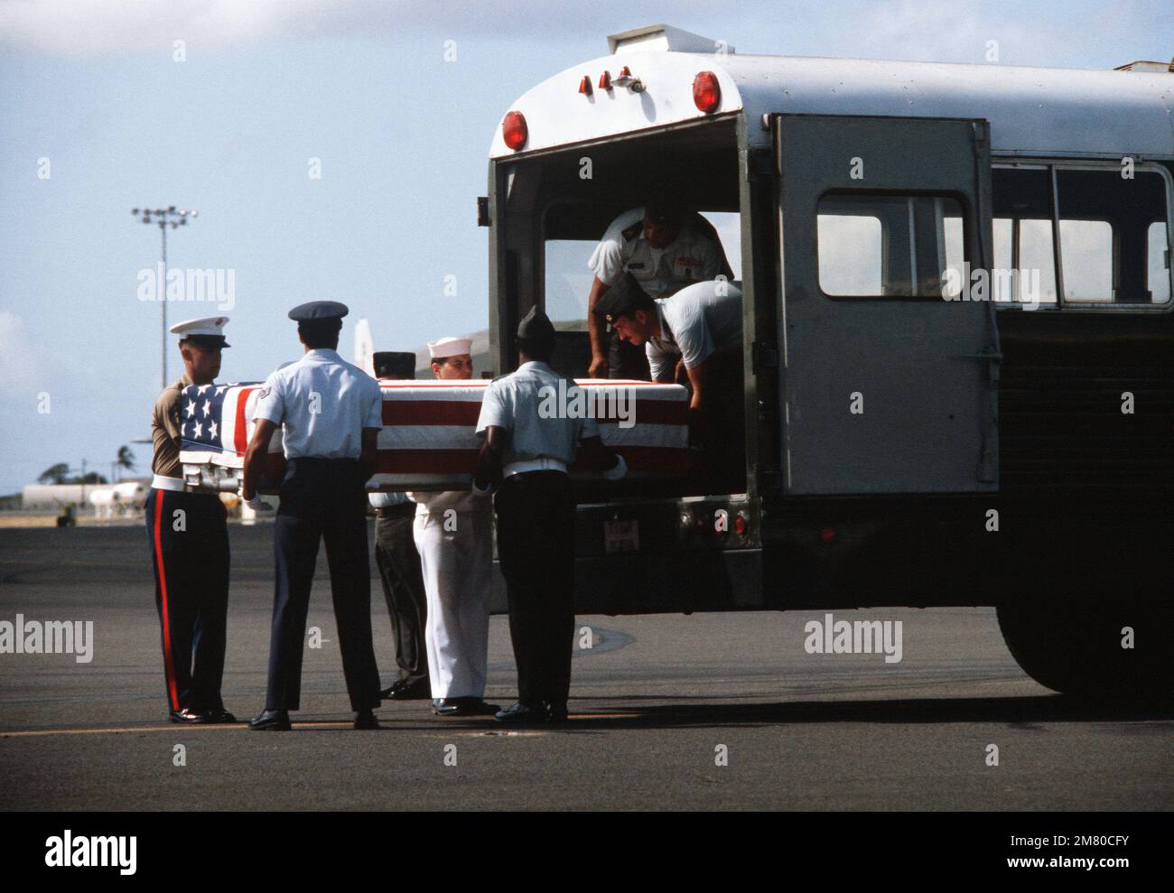 Combined service pallbearers lift the flag-draped casket of an American ...