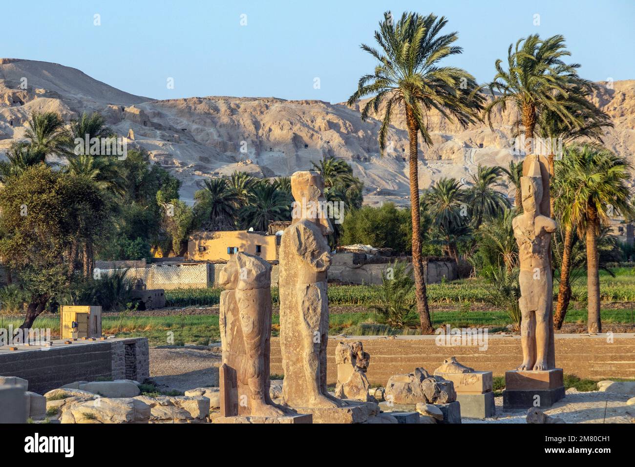 STATUES IN THE RUINS OF THE ANCIENT TEMPLE OF THEBES WITH ITS ...