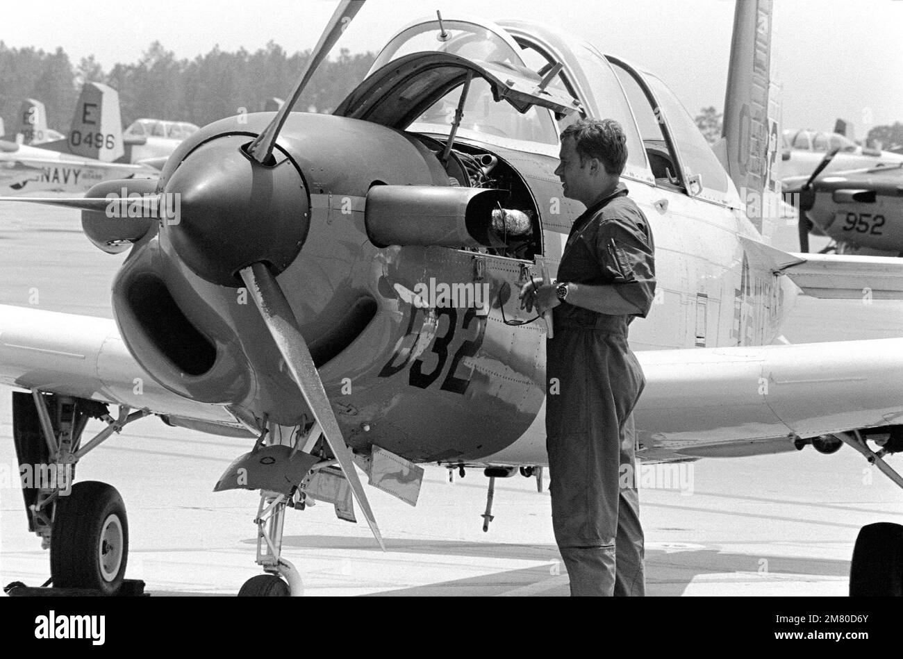 A ground crewman performs maintenance on a T-34C Mentor trainer ...