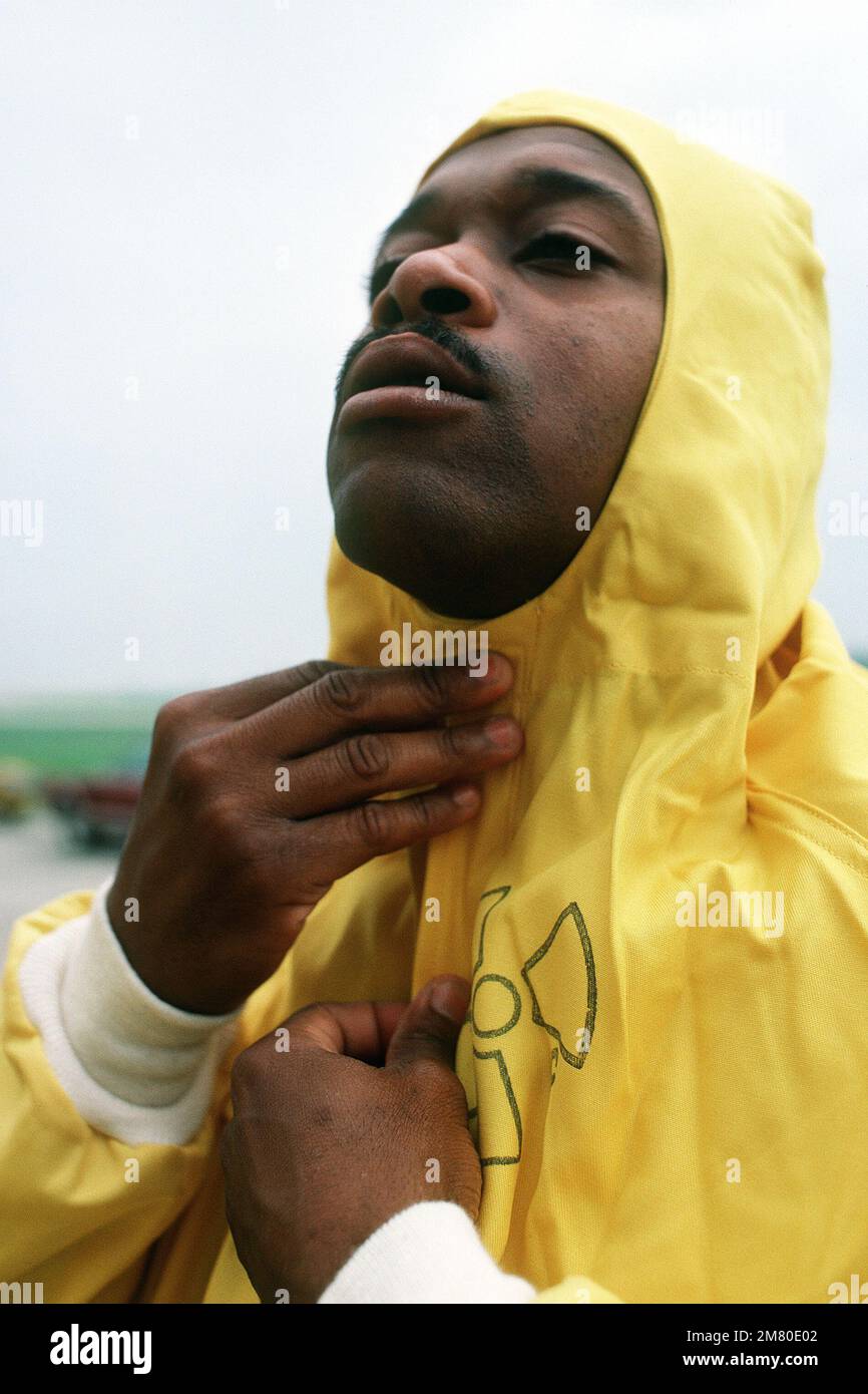 A member of the Disaster Response Force fastens the collar of his ...