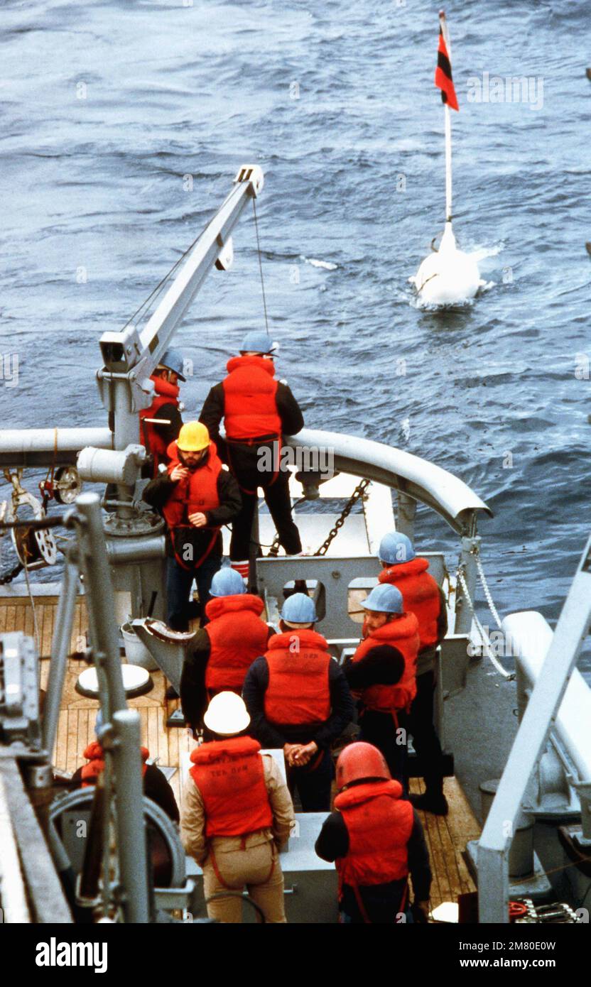Crewmen hoist a 900-pound buoy, or "pig", aboard the ocean minesweeper ...
