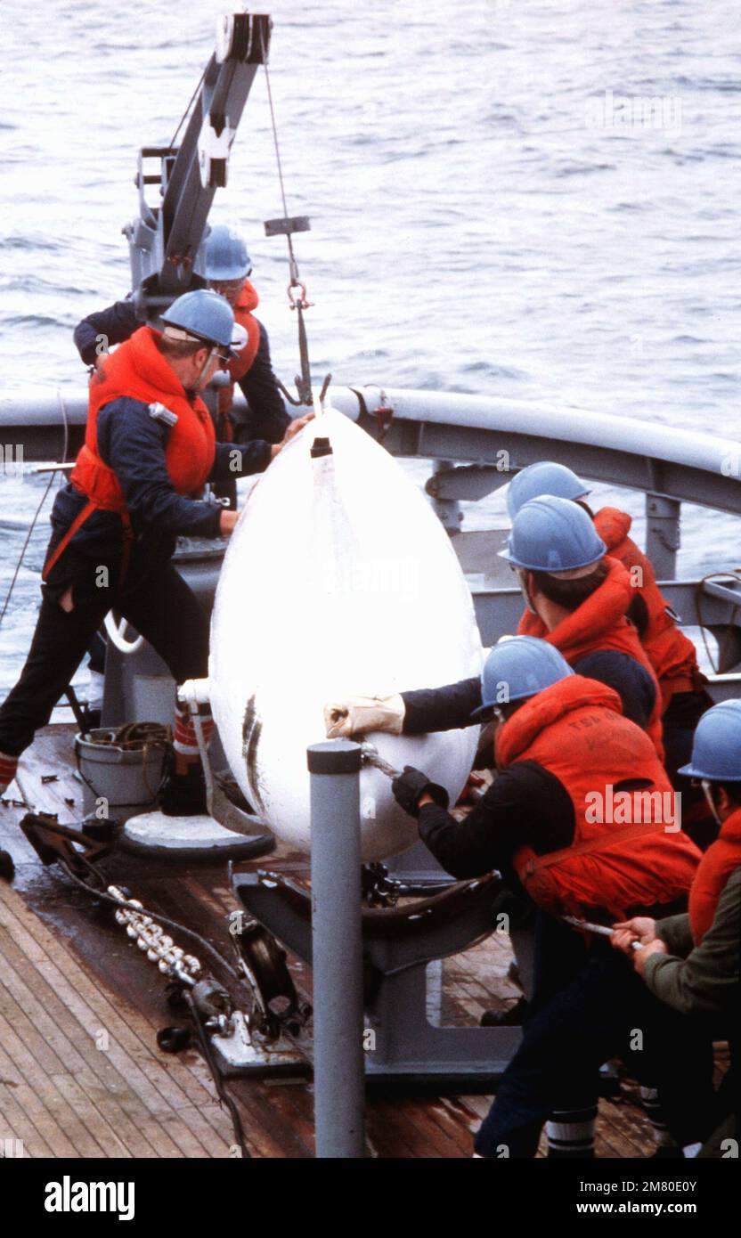 Crewmen hoist a 900-pound buoy, or "pig", aboard the ocean minesweeper ...