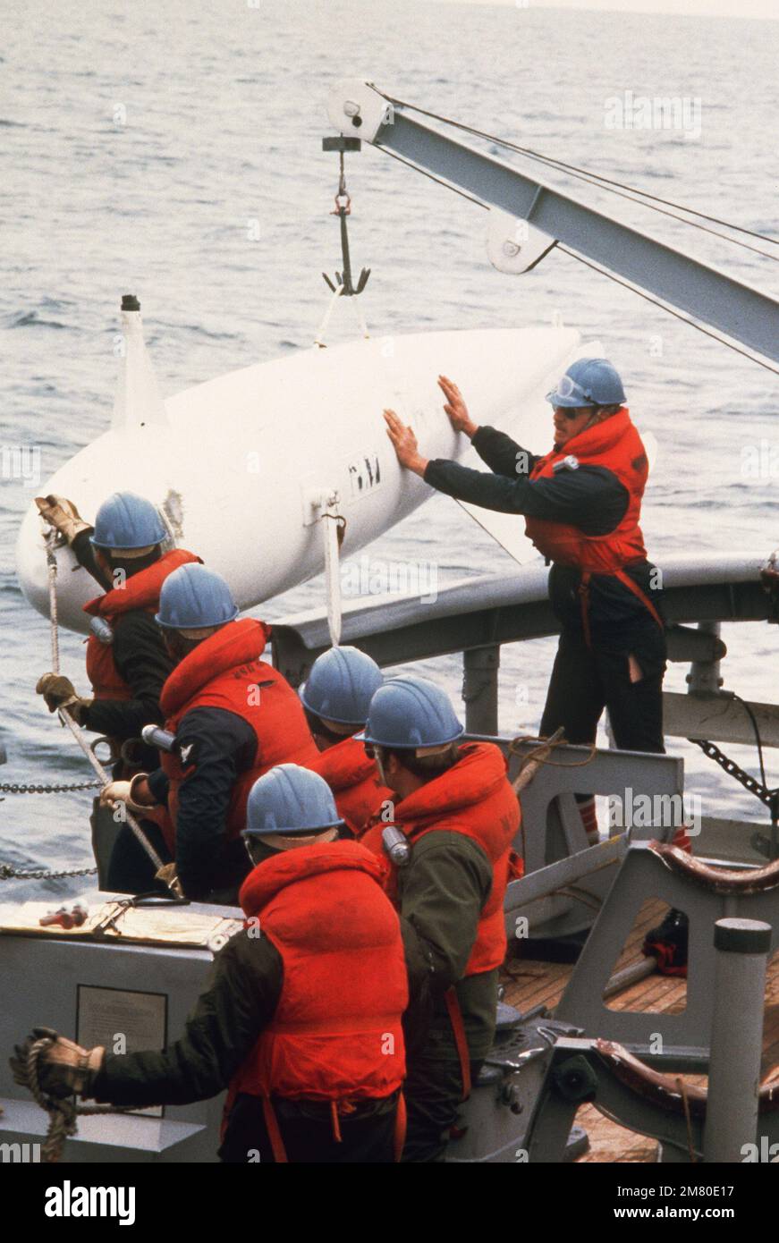 Crewmen hoist a 900-pound buoy, or "pig", aboard the ocean minesweeper ...