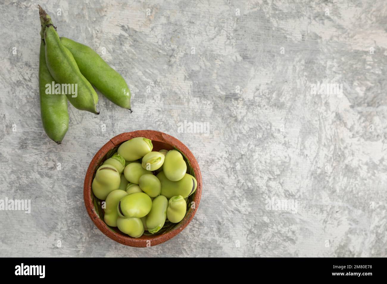 composition of peeled and shelled broad beans on a gray texture and ...