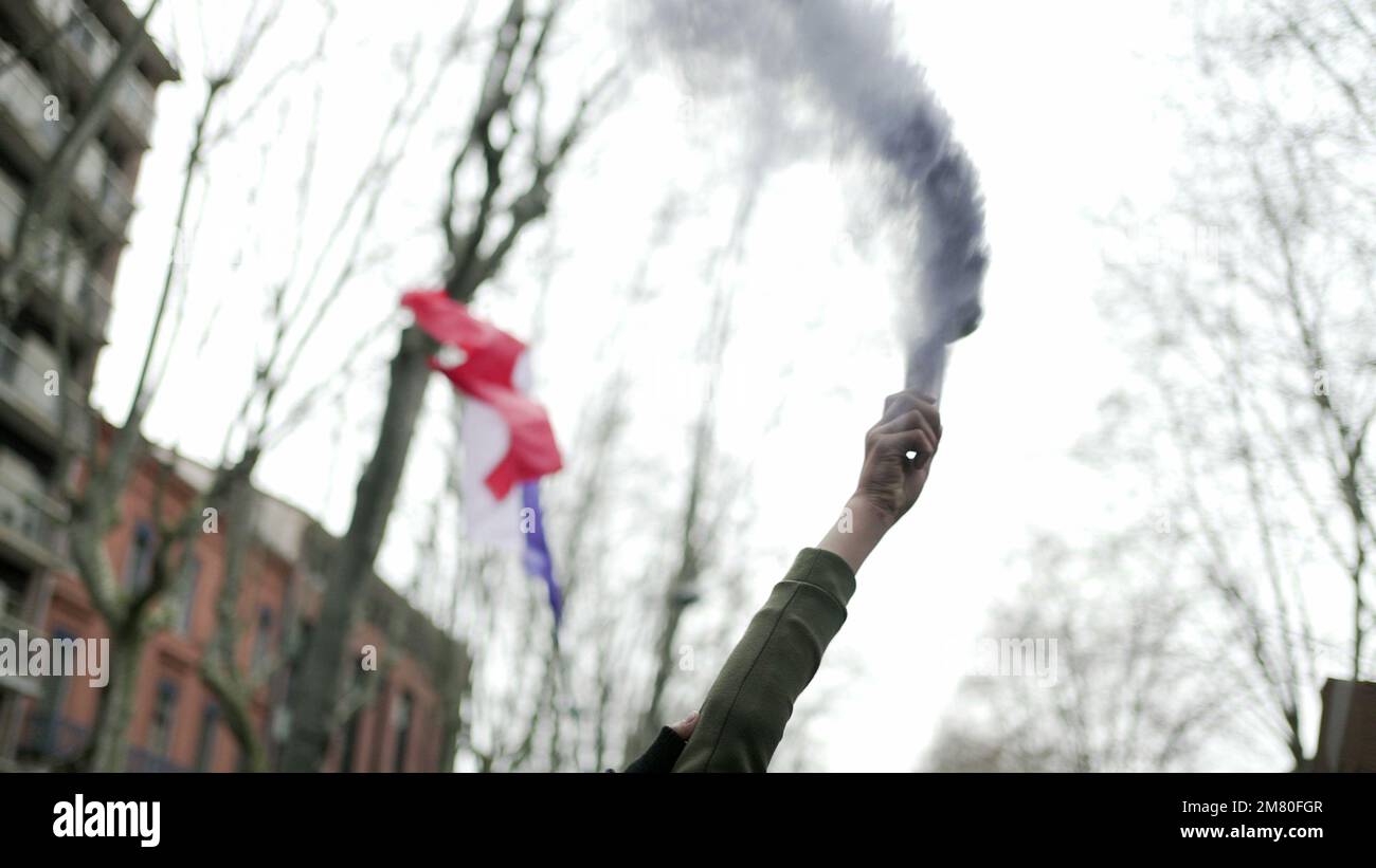Political manifestation, person hand holding smoke bomb grey color ...