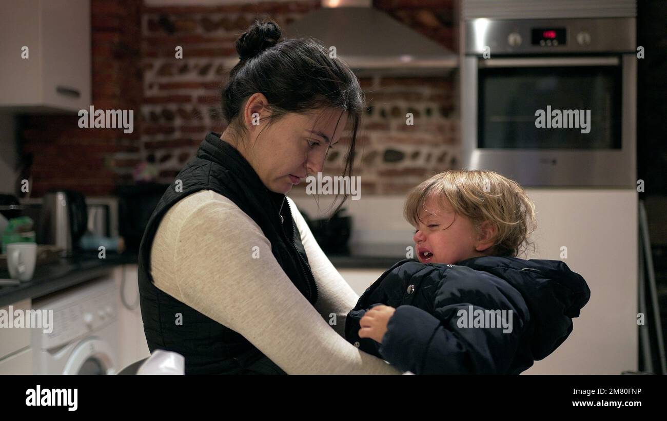 Mother consoling tearful crying baby toddler boy, casual and candid ...