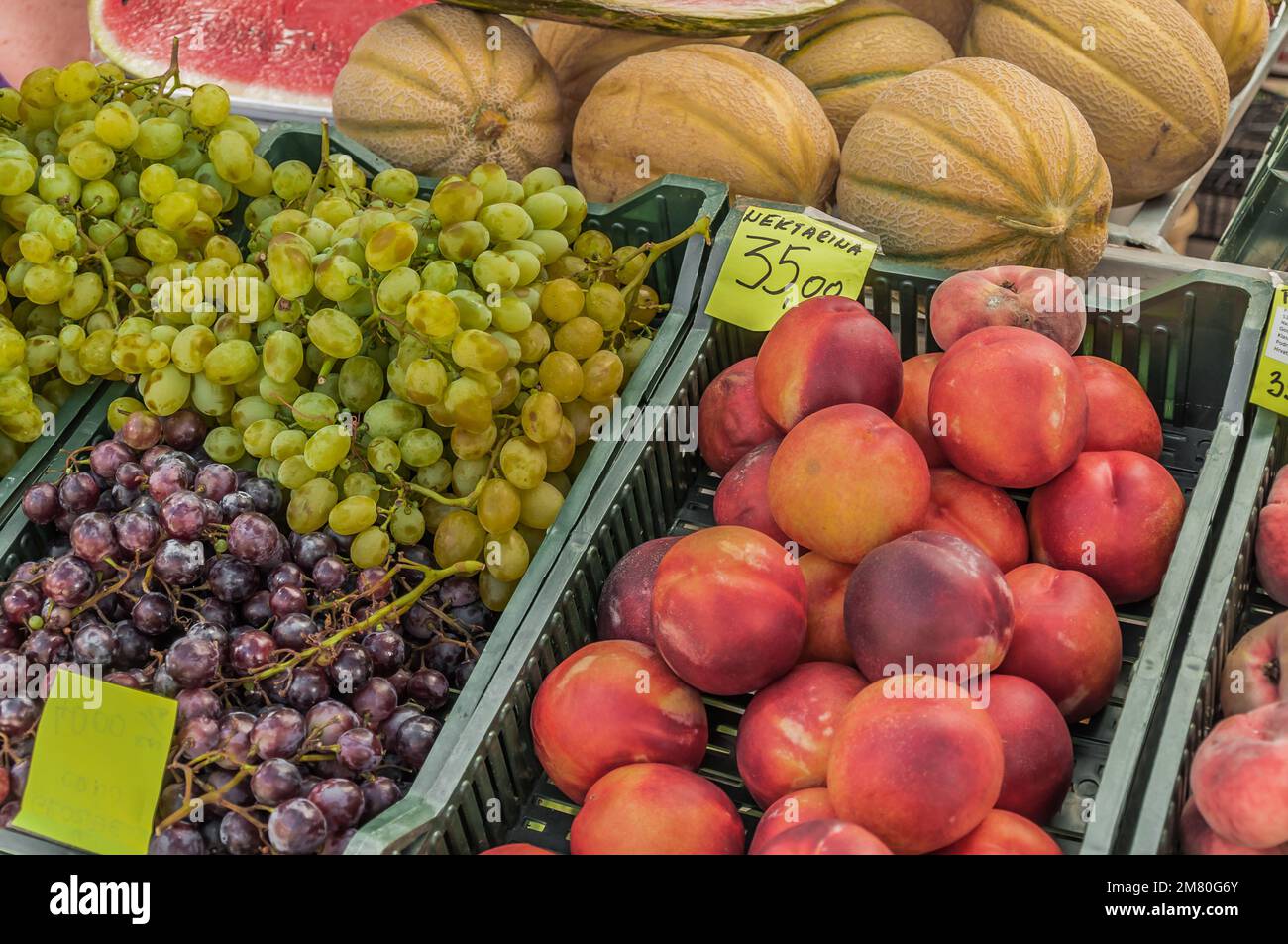 Peaches, grapes, sliced watermelon and ripe melons on the market Stock ...