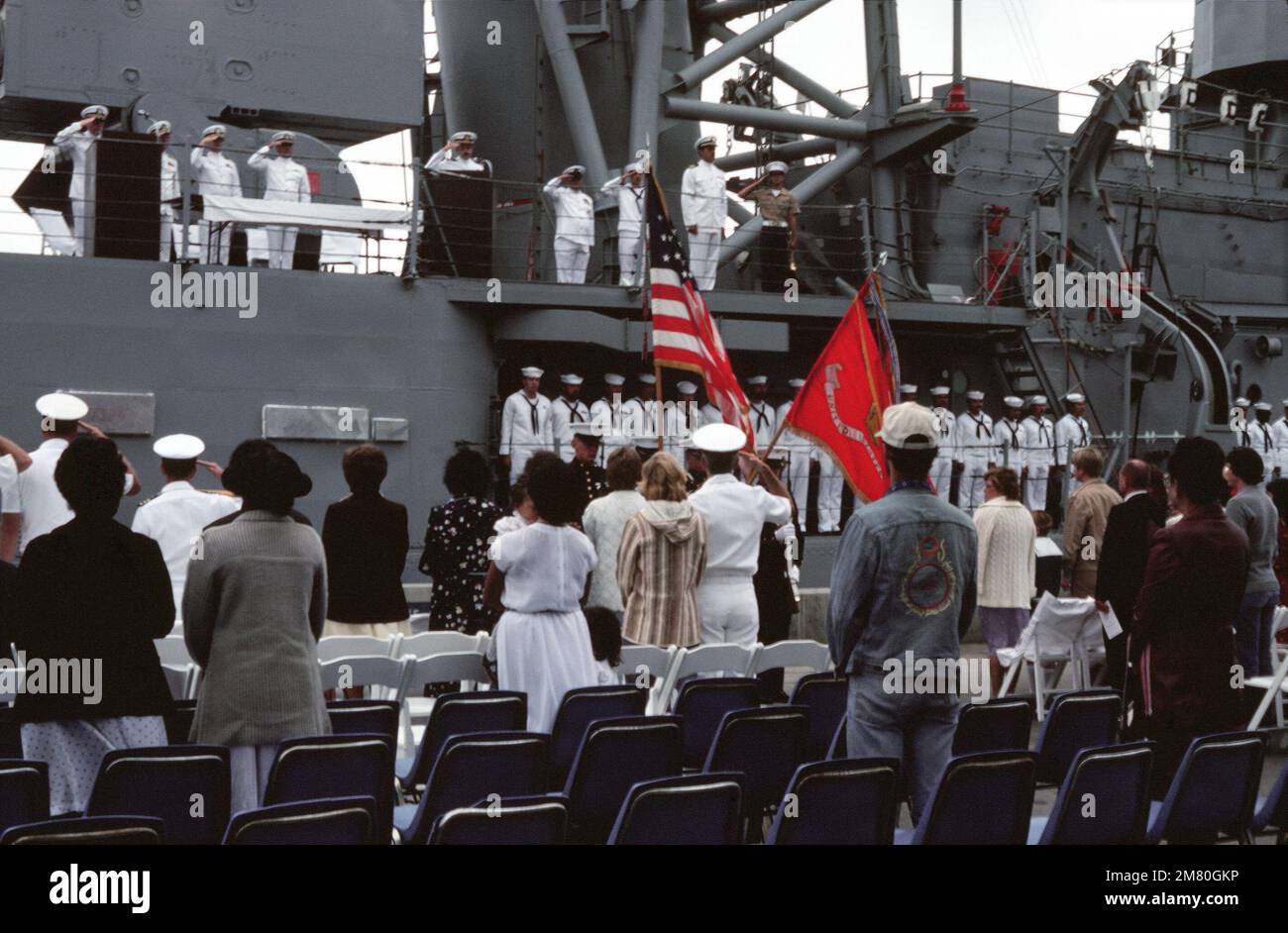 Crew members and guests stand at attention while a Marine color guard ...