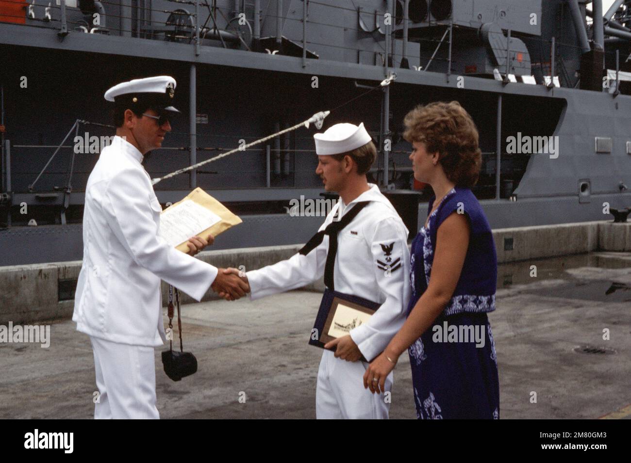 A petty officer 2nd Class is congratulated after he reenlisted during ...