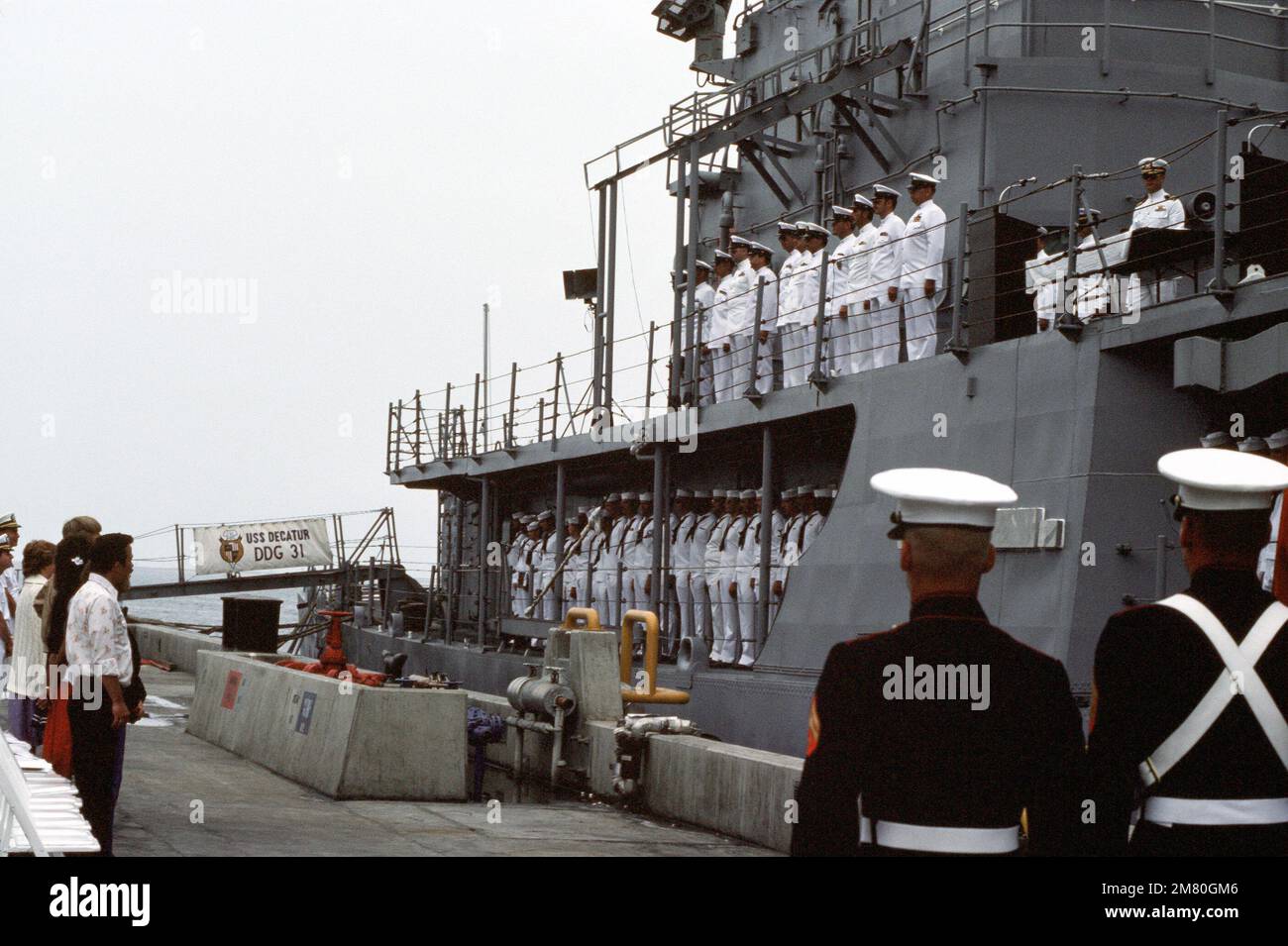 Crew members and guests stand at attention during the decommissioning ...