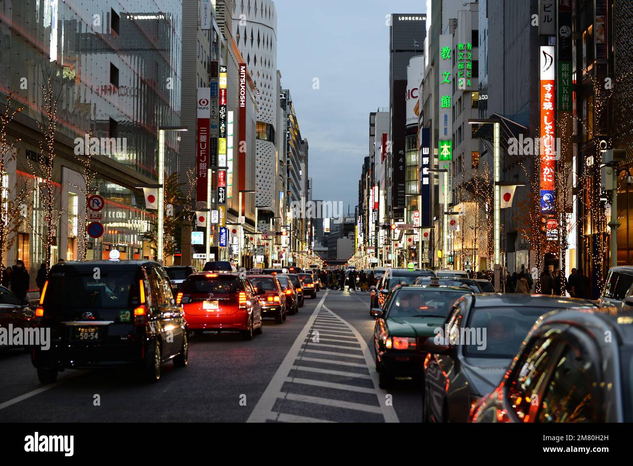 A beautiful shot of Ginza cars and buildings with neon signs in Tokyo ...
