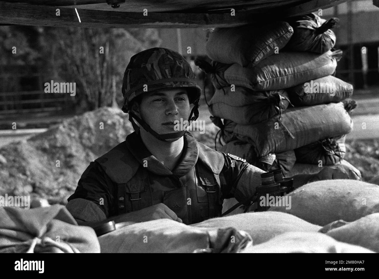 A Marine stands watch behind a bulwark as he participates as a member ...